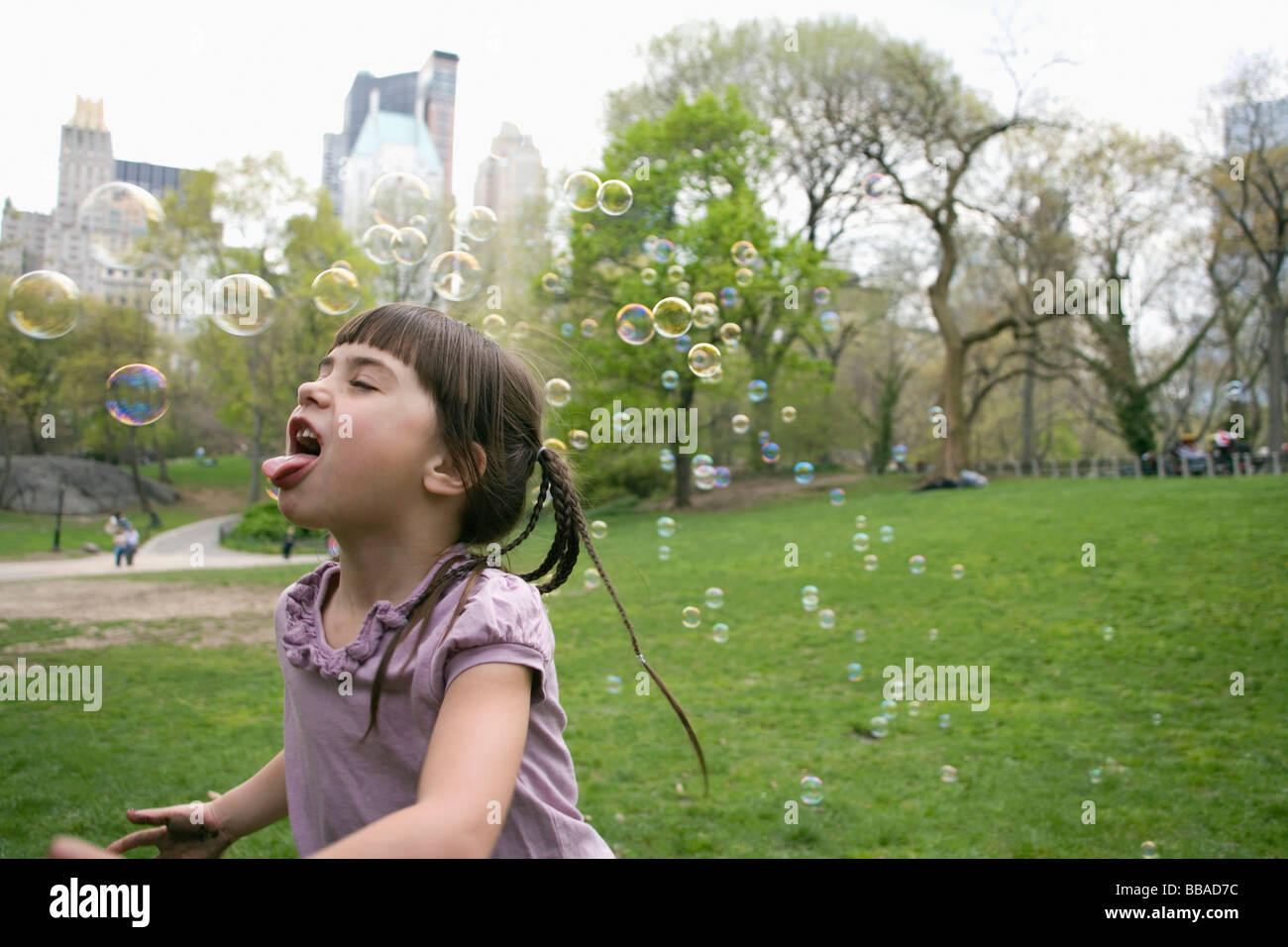 A young girl catching bubbles in Central Park, New York City Stock ...