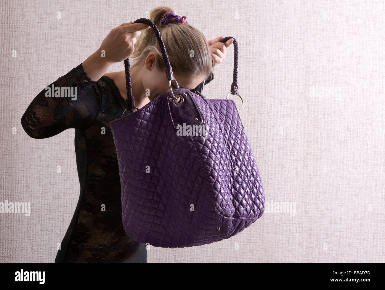 A woman looking into her large purse Stock Photo - Alamy