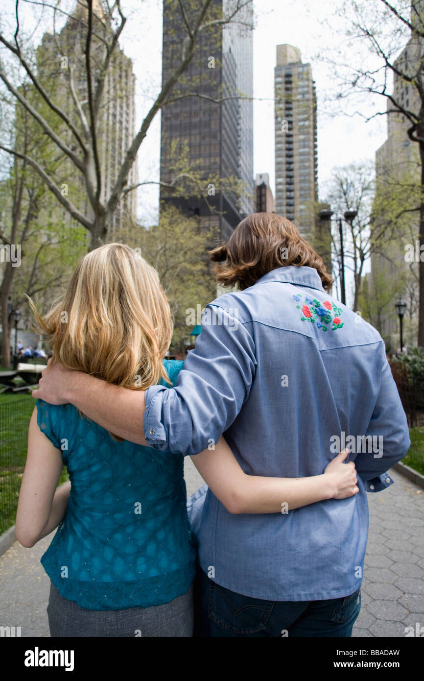 A young couple walking arm in arm through a city park, Central Park ...