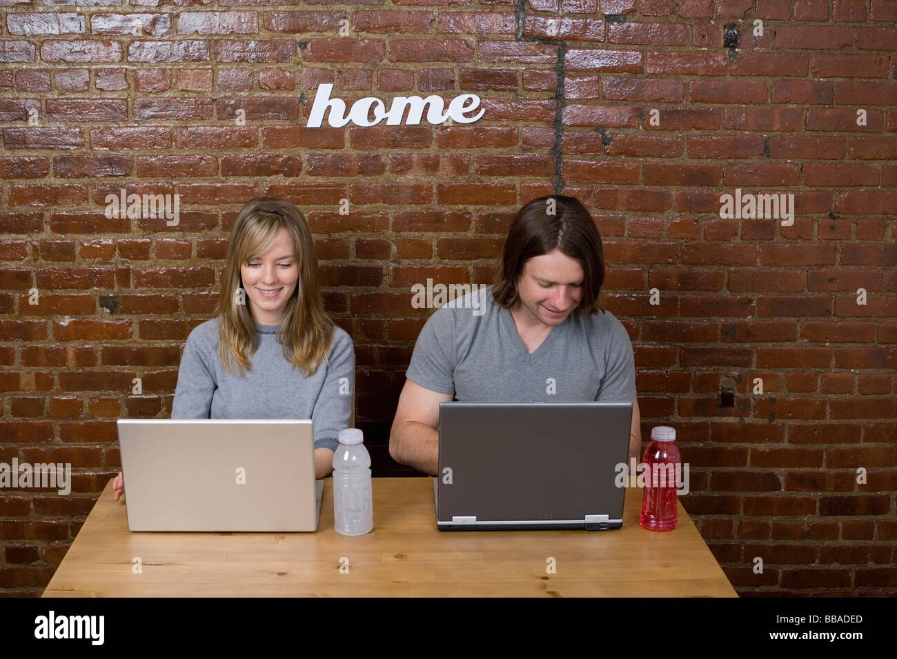 A young couple using laptops side by side Stock Photo - Alamy