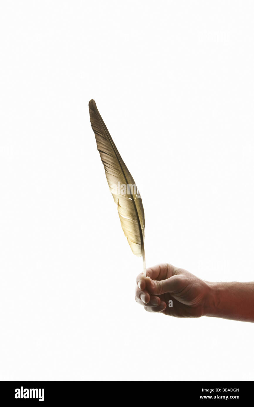 A human hand holding a feather Stock Photo - Alamy