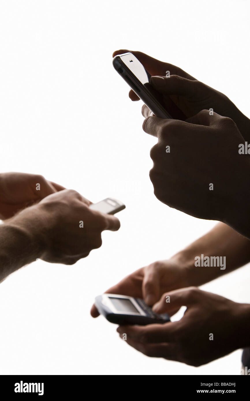 The hands of three people using mobile phones Stock Photo - Alamy