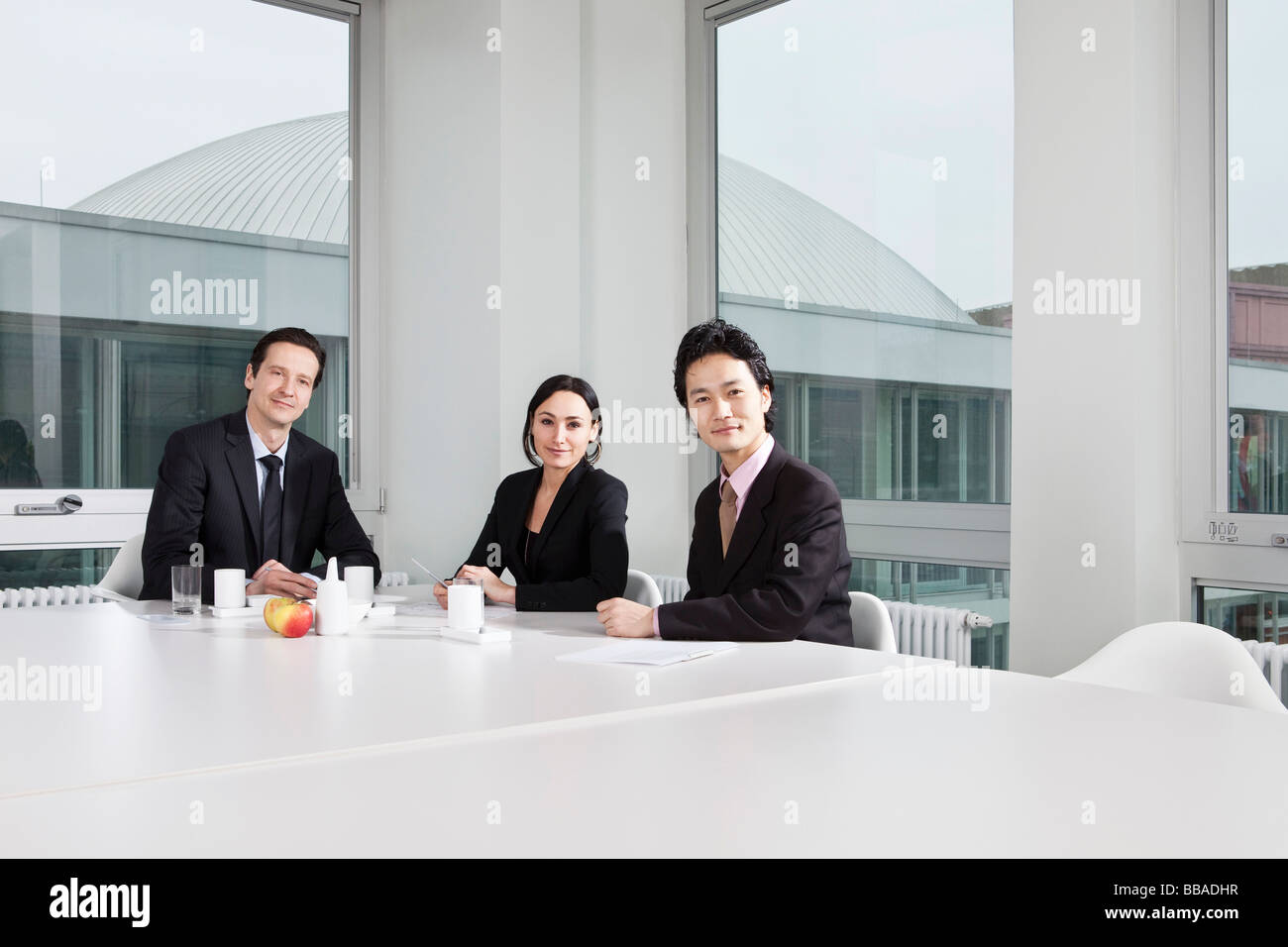 Portrait of three business people in a meeting Stock Photo - Alamy