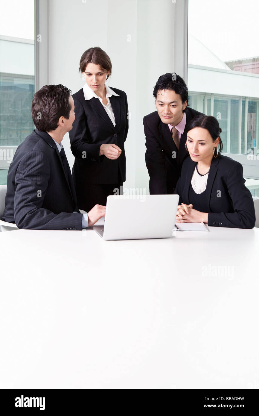 Four business people in a meeting using a laptop Stock Photo - Alamy