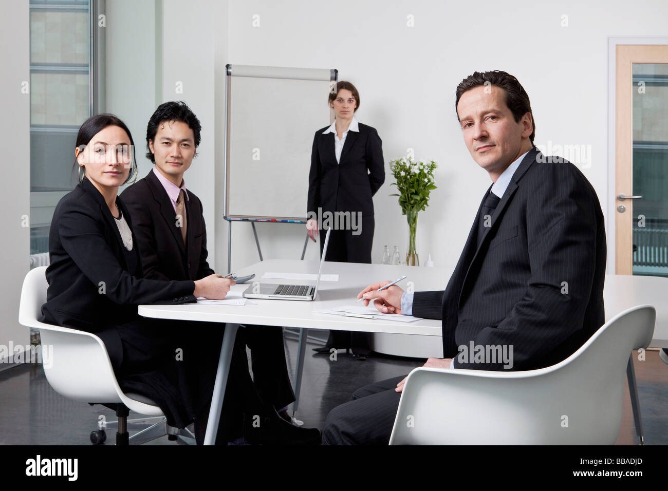 Portrait of four business people in a meeting Stock Photo - Alamy