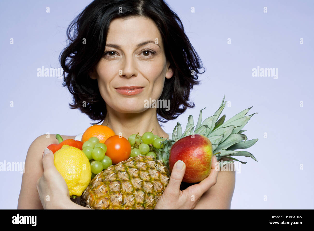 A woman holding various fruit Stock Photo - Alamy