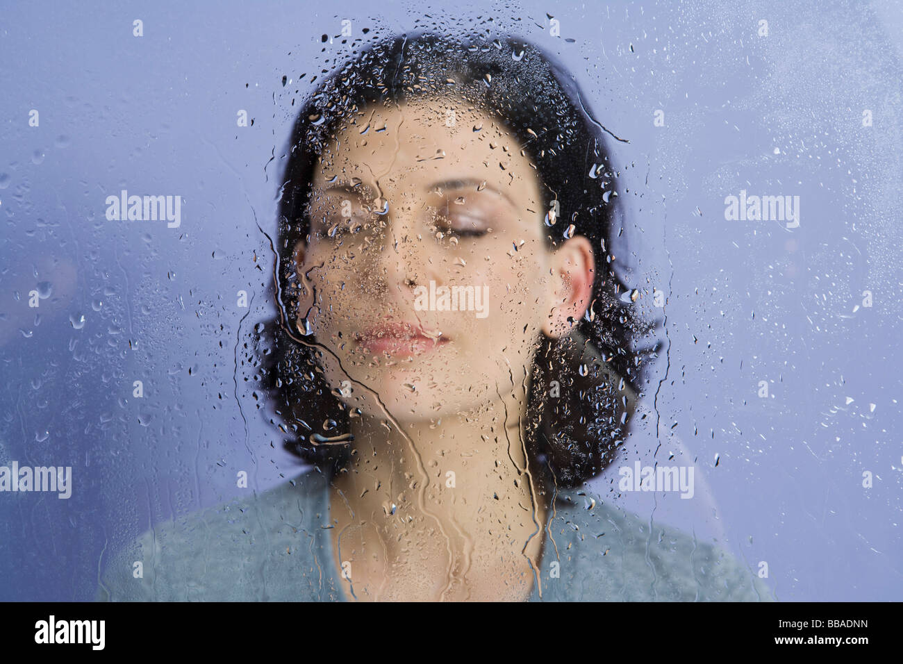 A woman behind wet glass Stock Photo - Alamy