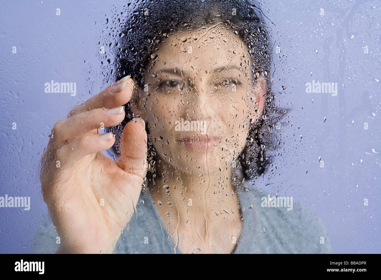 A woman behind wet glass Stock Photo - Alamy