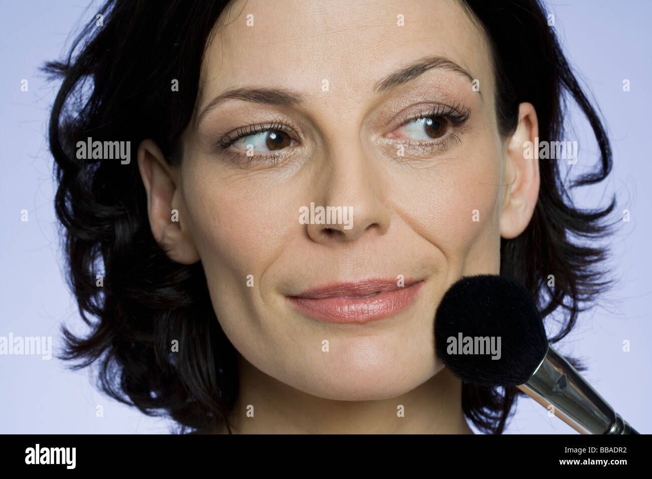 A woman applying face powder Stock Photo - Alamy