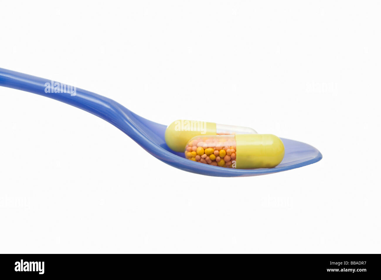 A spoon with two medicine capsules Stock Photo - Alamy