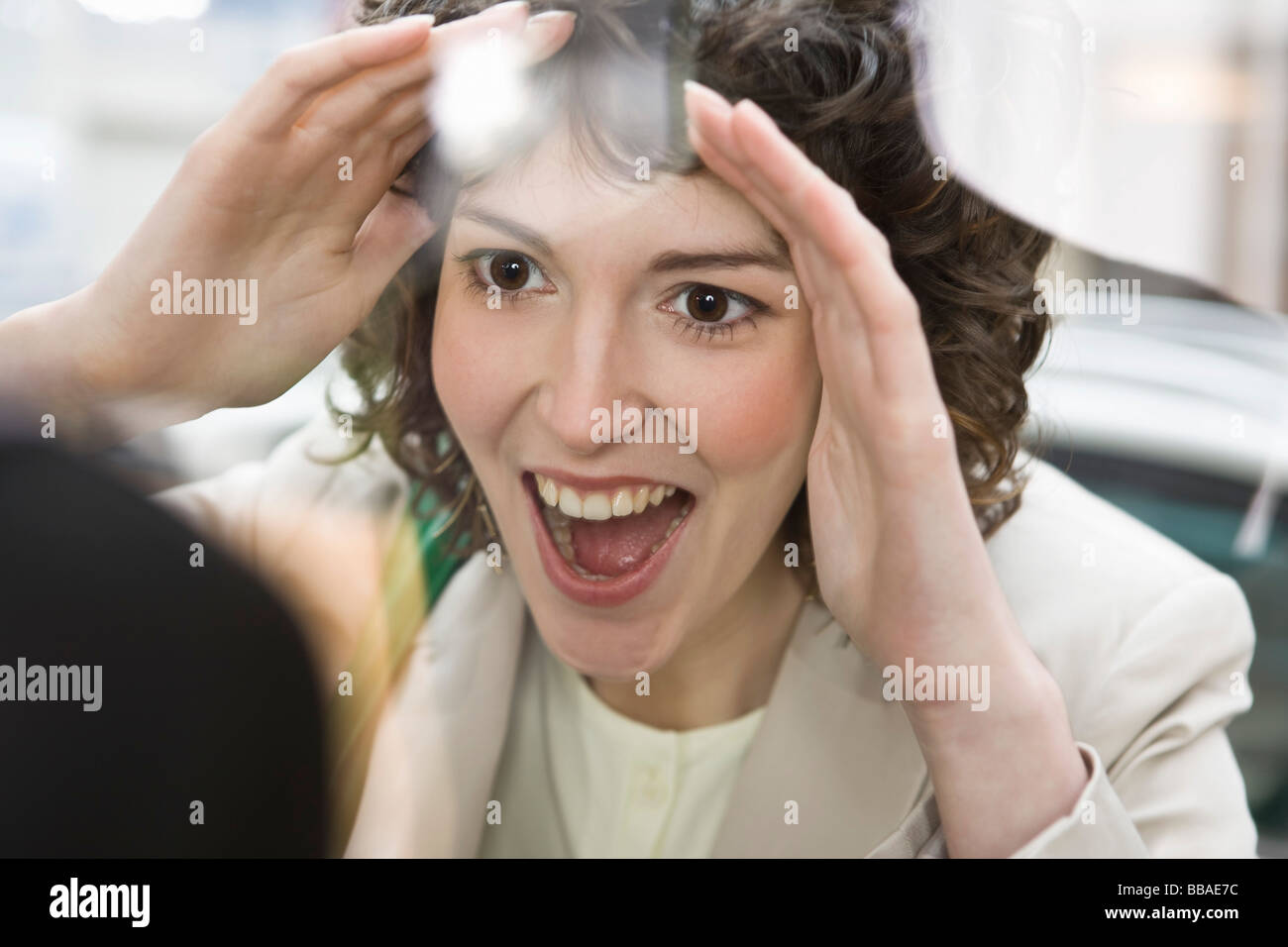 A woman looking with excitement through a store window Stock Photo - Alamy