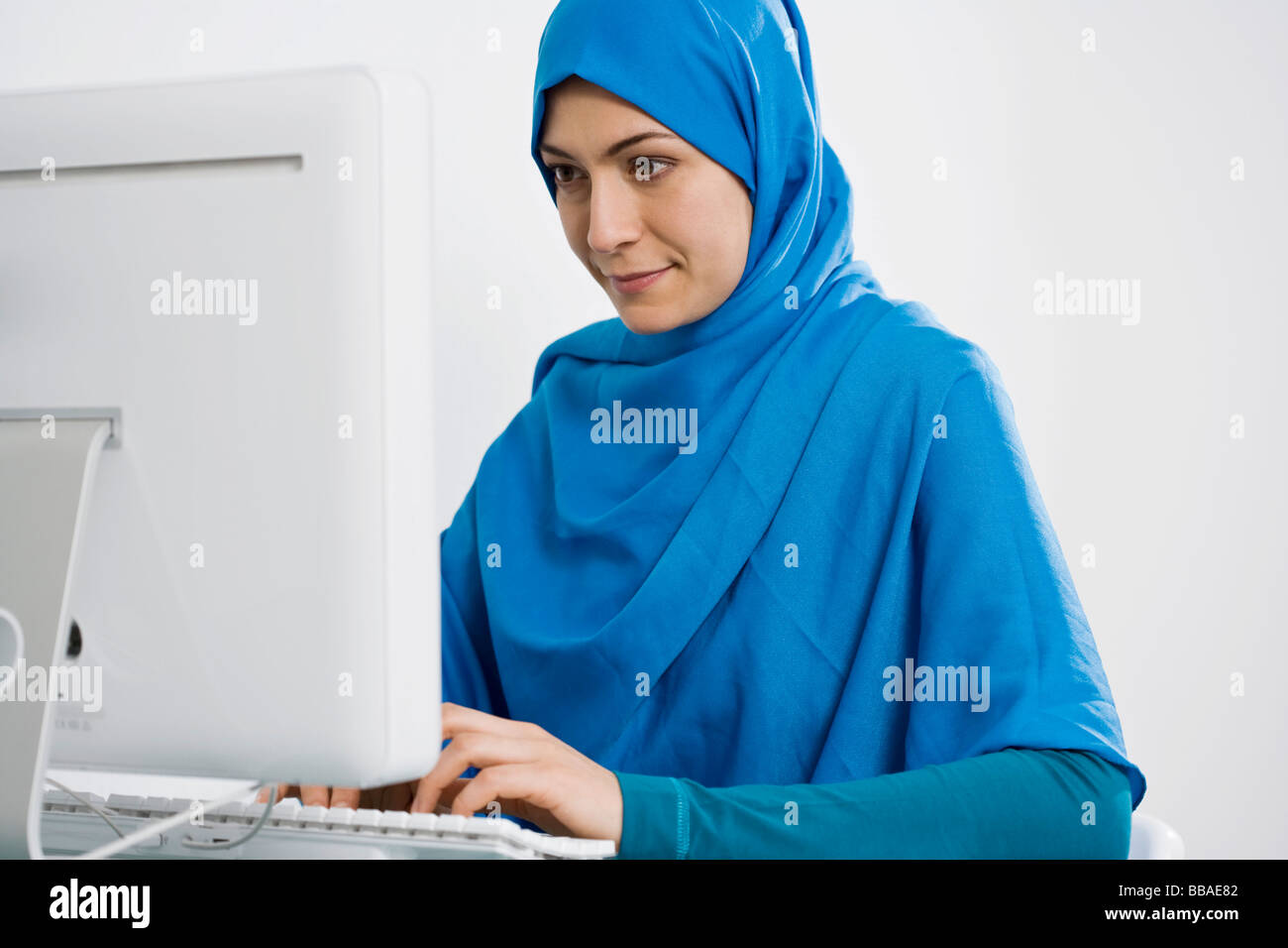 A woman wearing a Hijab using a computer Stock Photo - Alamy