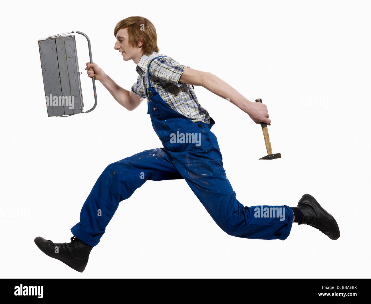 A young man running with a toolbox and hammer Stock Photo - Alamy