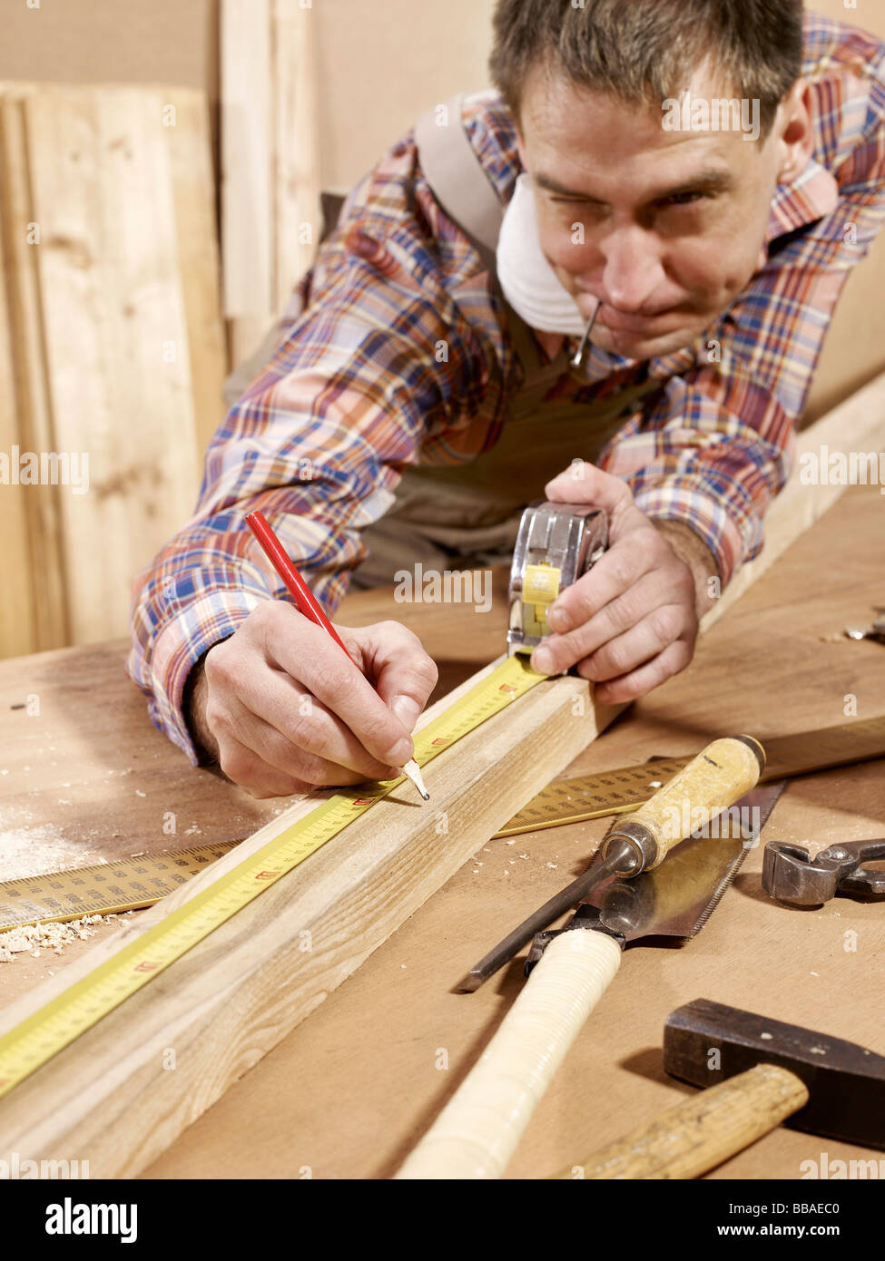 Man marking piece of timber using pencil and tape measure Stock Photo ...