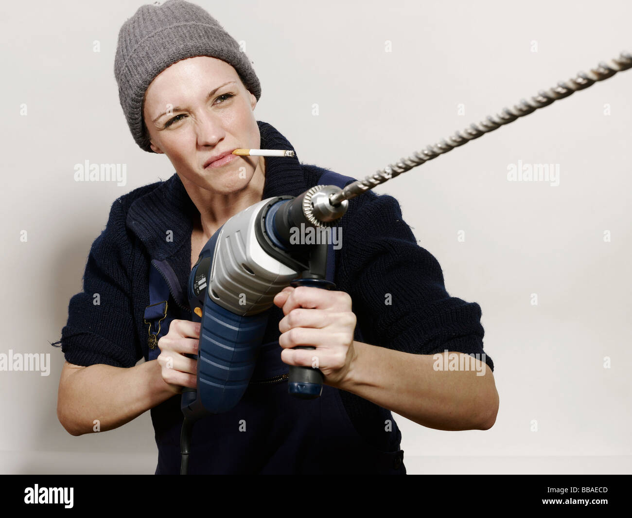A woman holding a large drill Stock Photo - Alamy