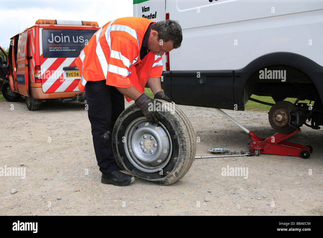 Breakdown recovery man changes the tyre on a white panel van Stock ...