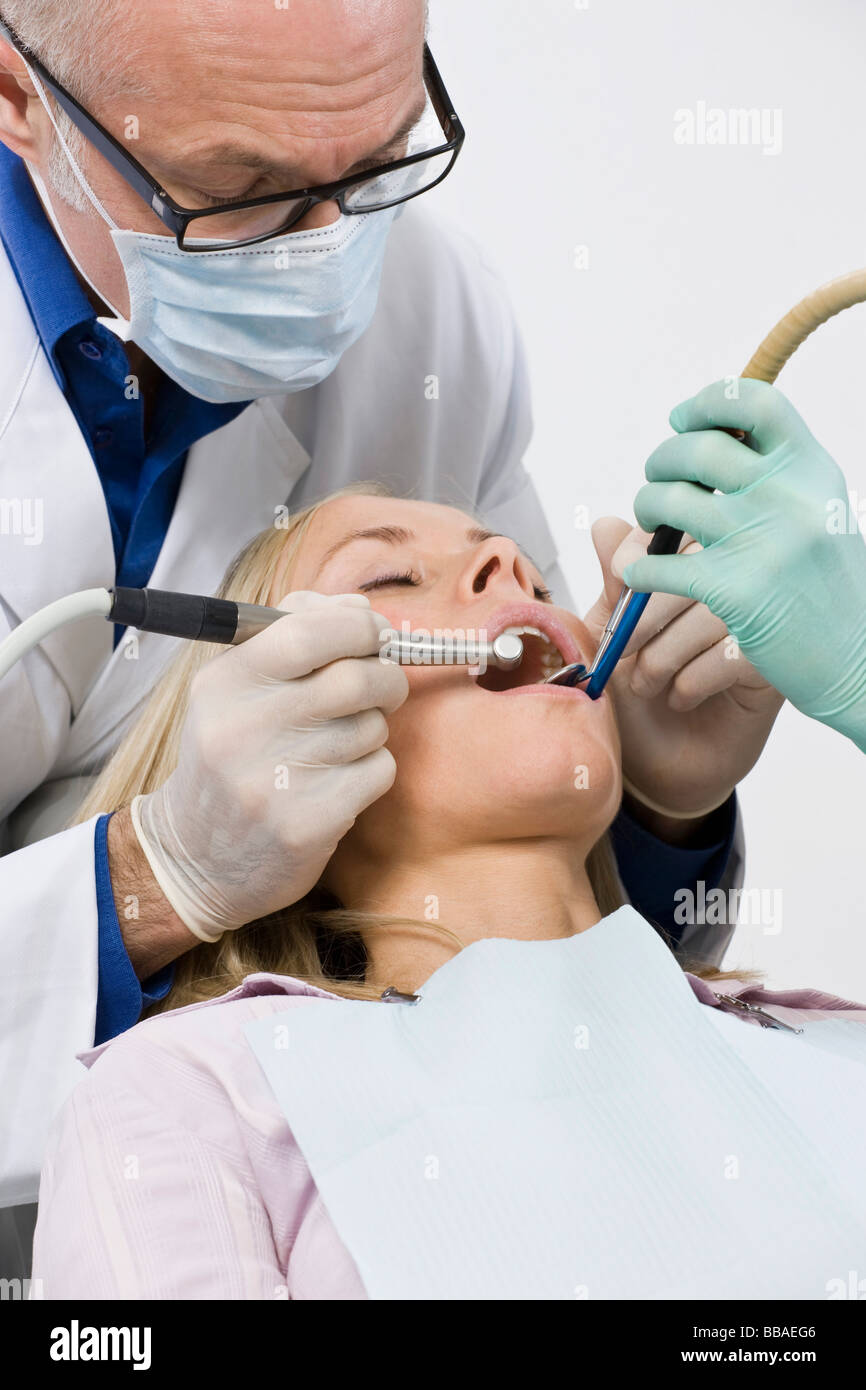A dentist inspecting a woman's mouth Stock Photo - Alamy
