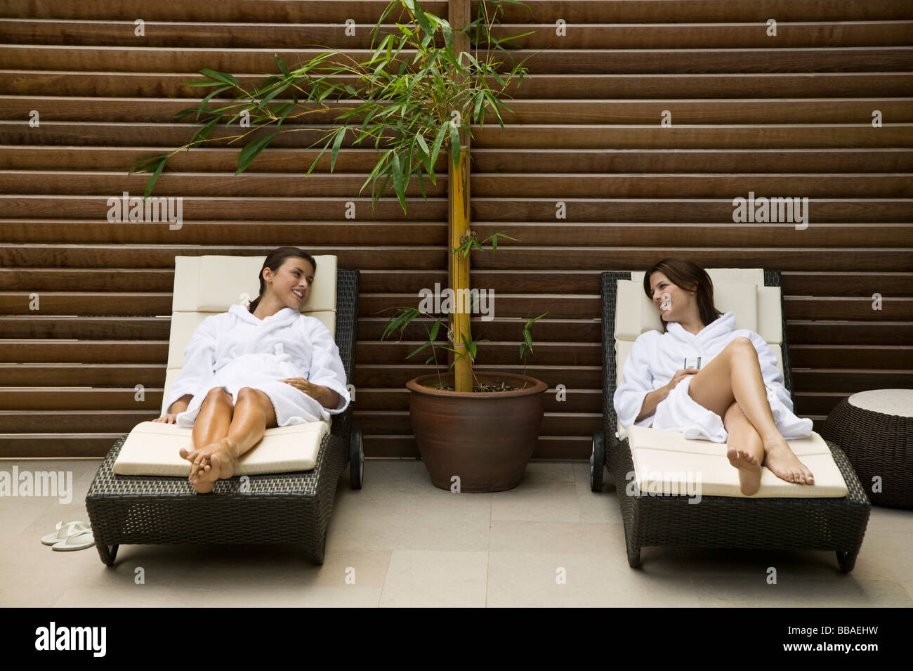 Two women lying in lounge chairs Stock Photo - Alamy