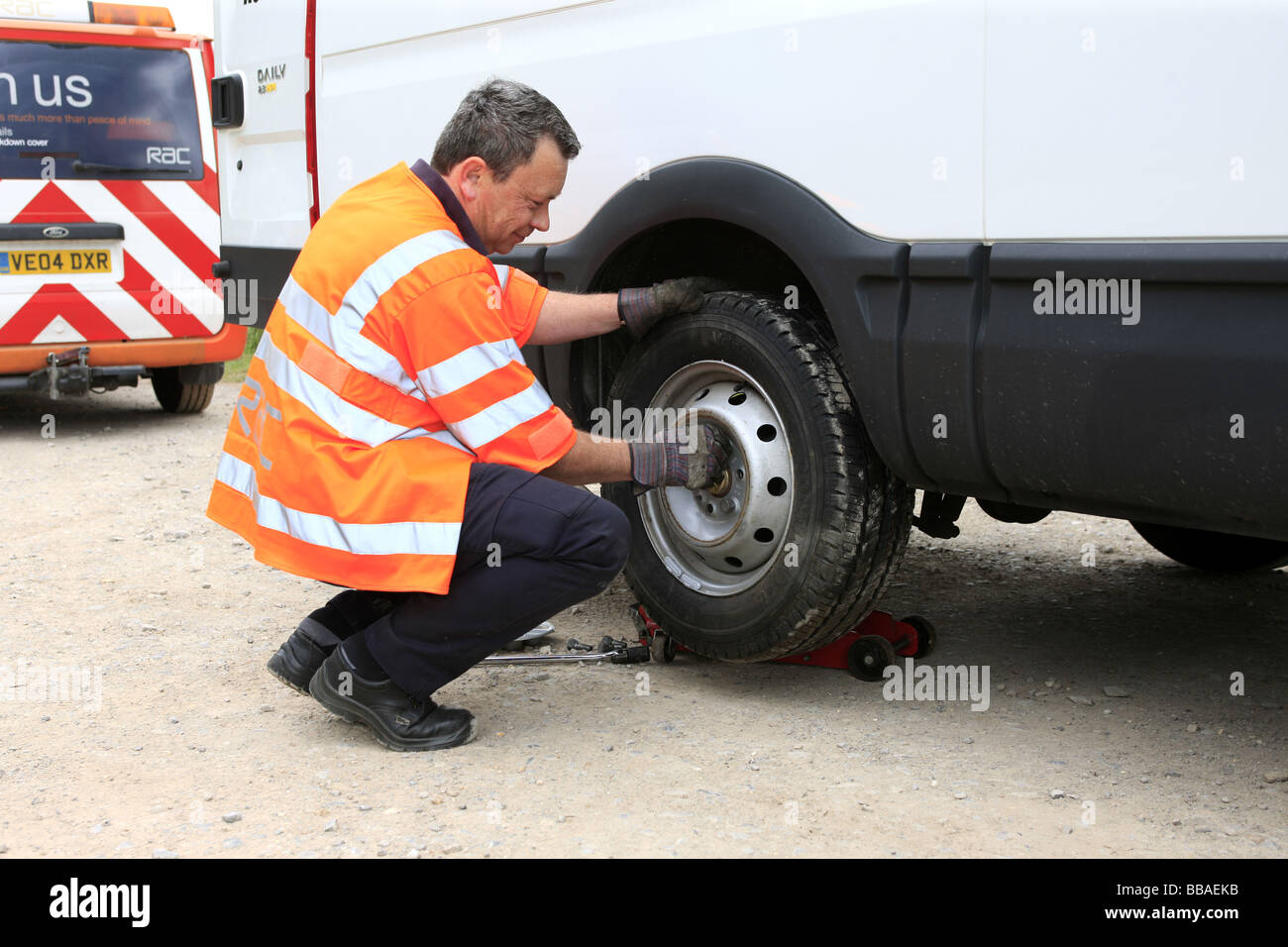 Breakdown recovery man changes the tyre on a white panel van Stock ...