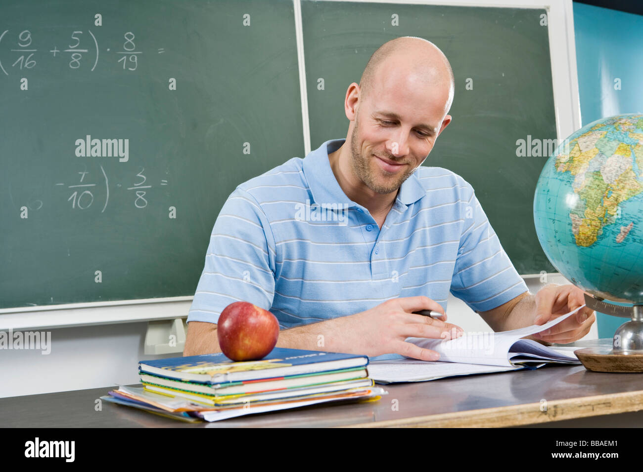 A teacher sitting at a desk Stock Photo - Alamy