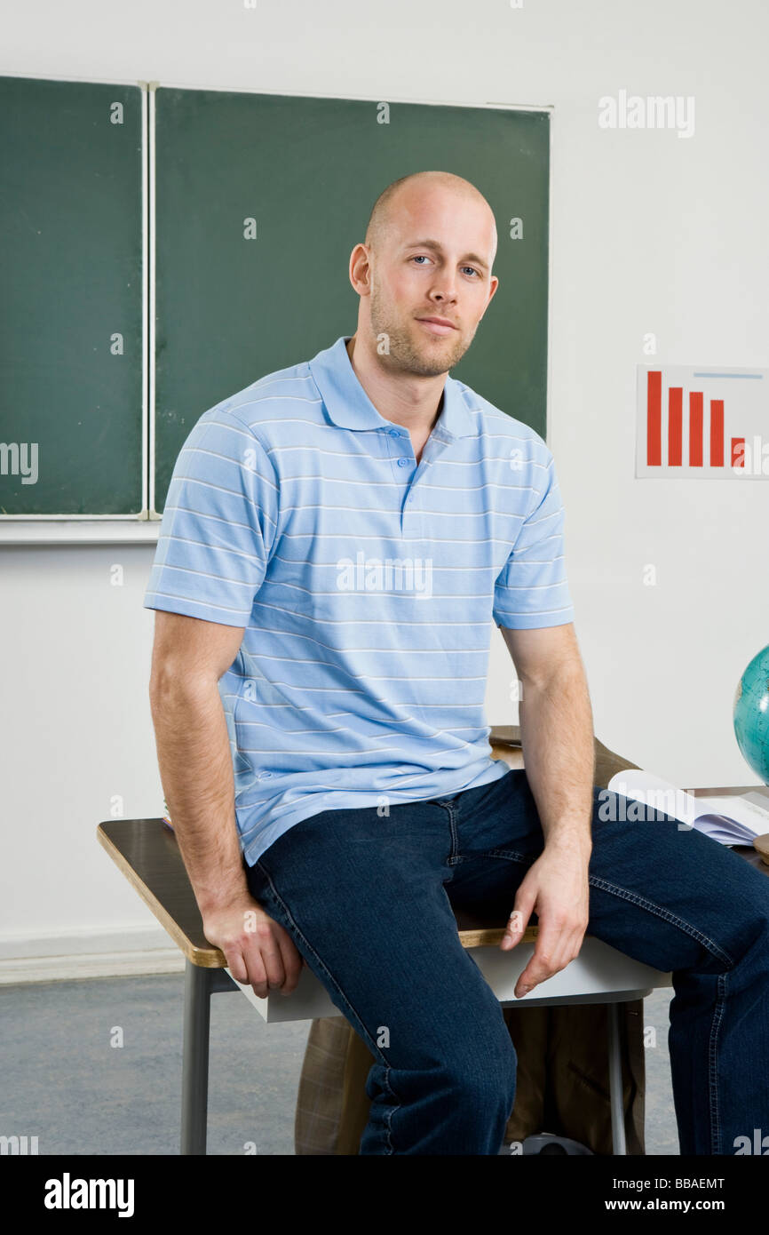 A teacher sitting on a desk Stock Photo - Alamy