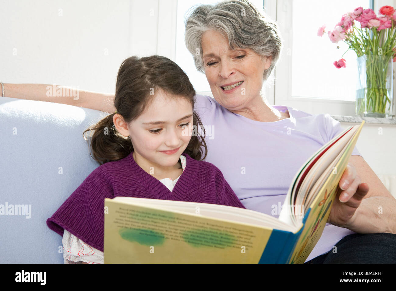 A grandmother reading a book with her granddaughter Stock Photo - Alamy