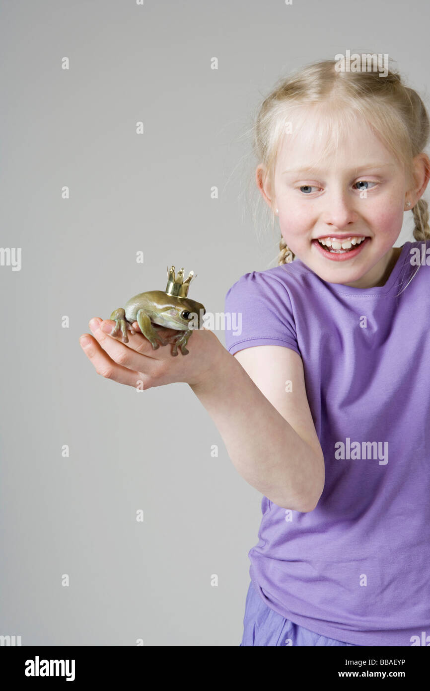 A girl holding a frog prince Stock Photo - Alamy