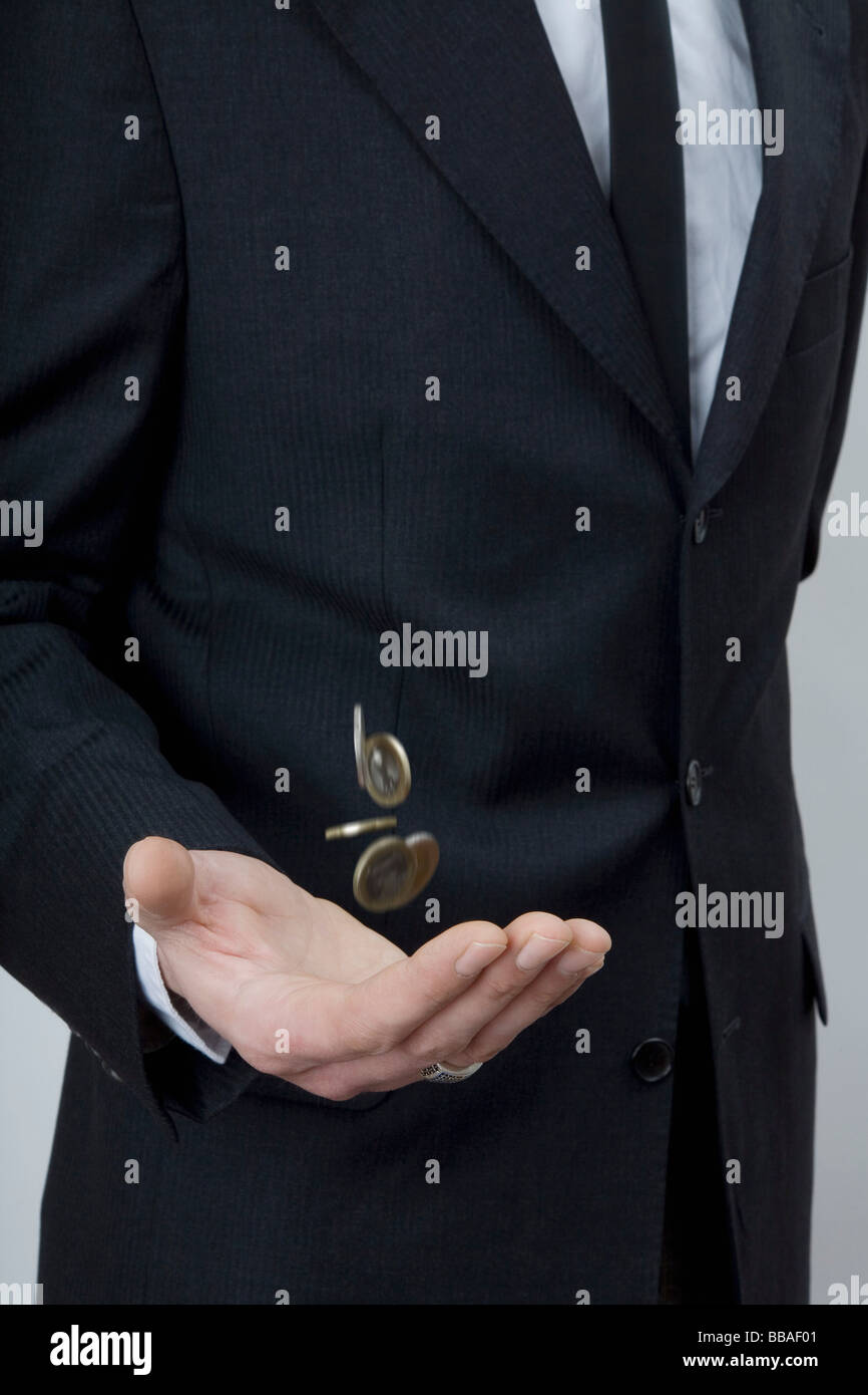 A man in a suit tossing change with his hand Stock Photo - Alamy