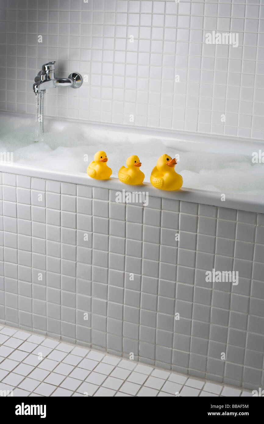 A bubble bath with rubber ducks on side of tub Stock Photo - Alamy