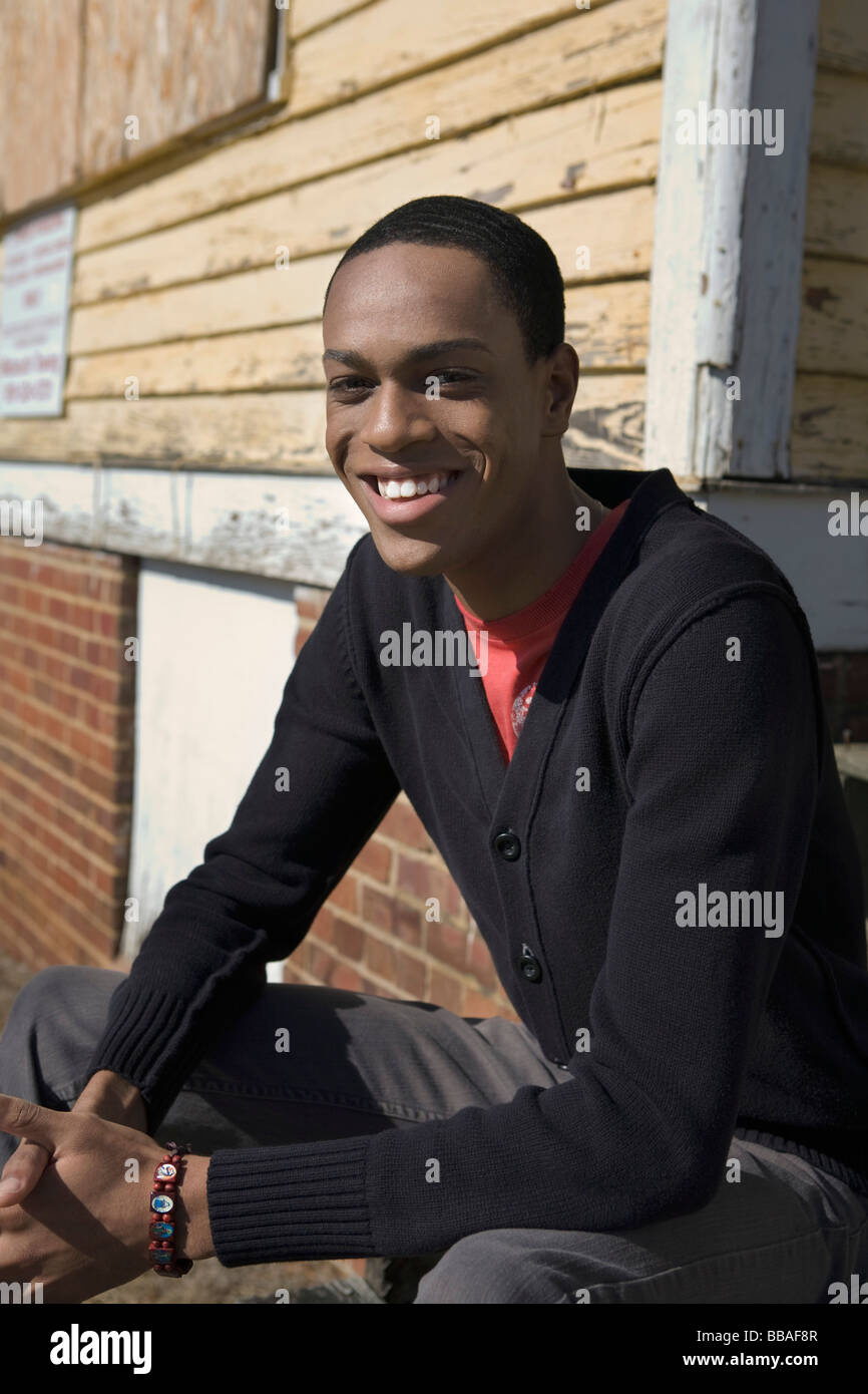 A young man sitting on porch steps Stock Photo - Alamy