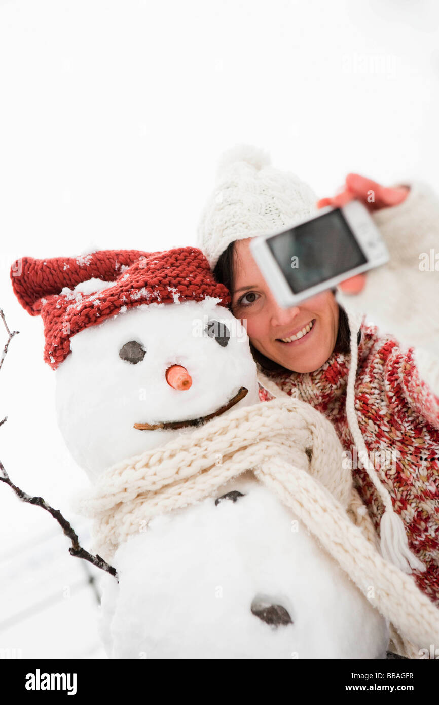 woman taking photo of snowman Stock Photo - Alamy