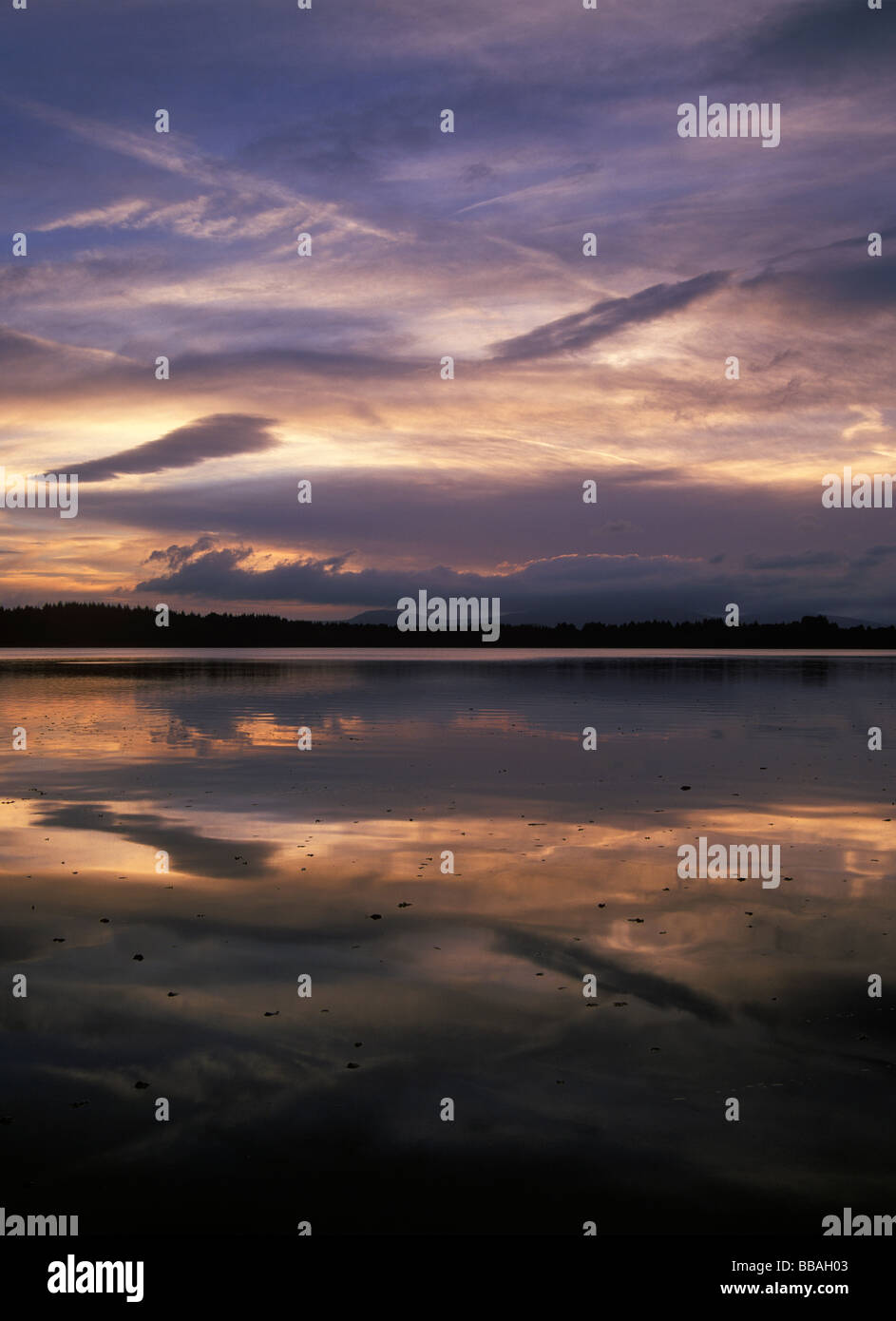 Sunset reflected in a small loch, Loch Lomond & The Trossachs National ...