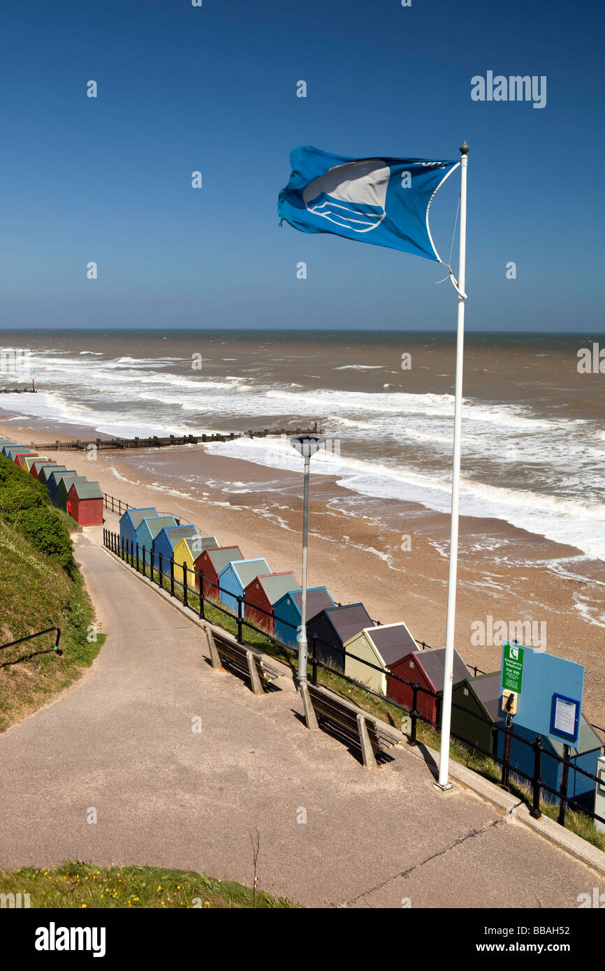 UK England Norfolk Mundesley seafront beach huts behind blue flag clean ...