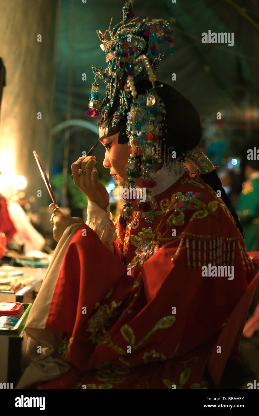 Chinese Bangkok opera performer applying her makeup before the evening ...