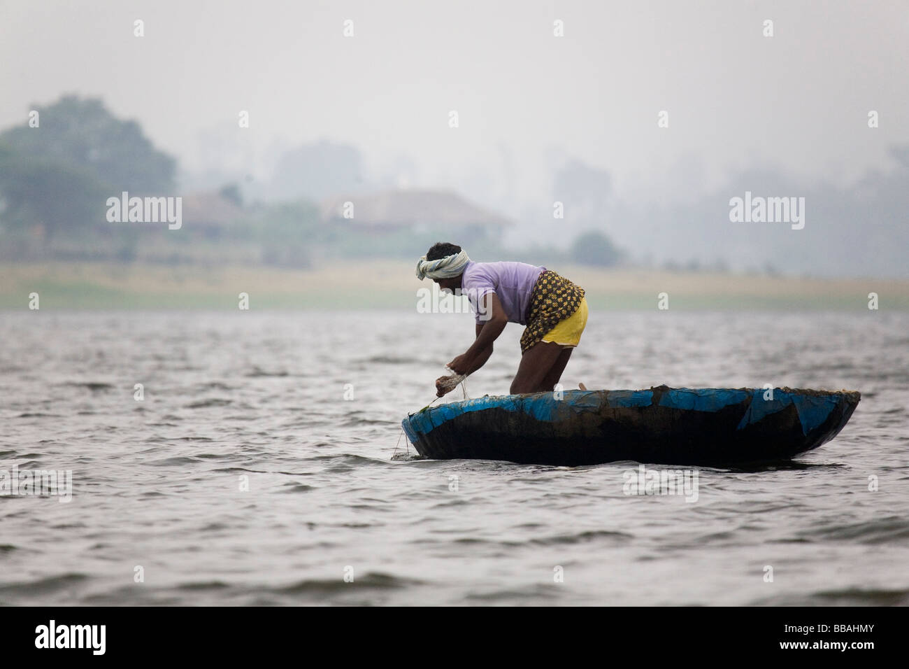 A fisherman in southern India lays his nets in a traditional round ...