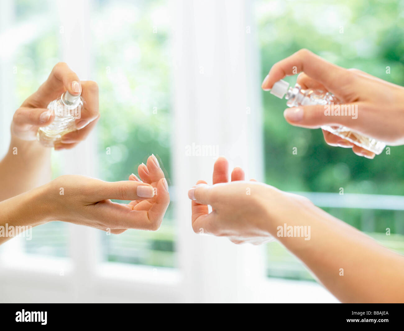 Reflection of hands spraying perfume Stock Photo - Alamy