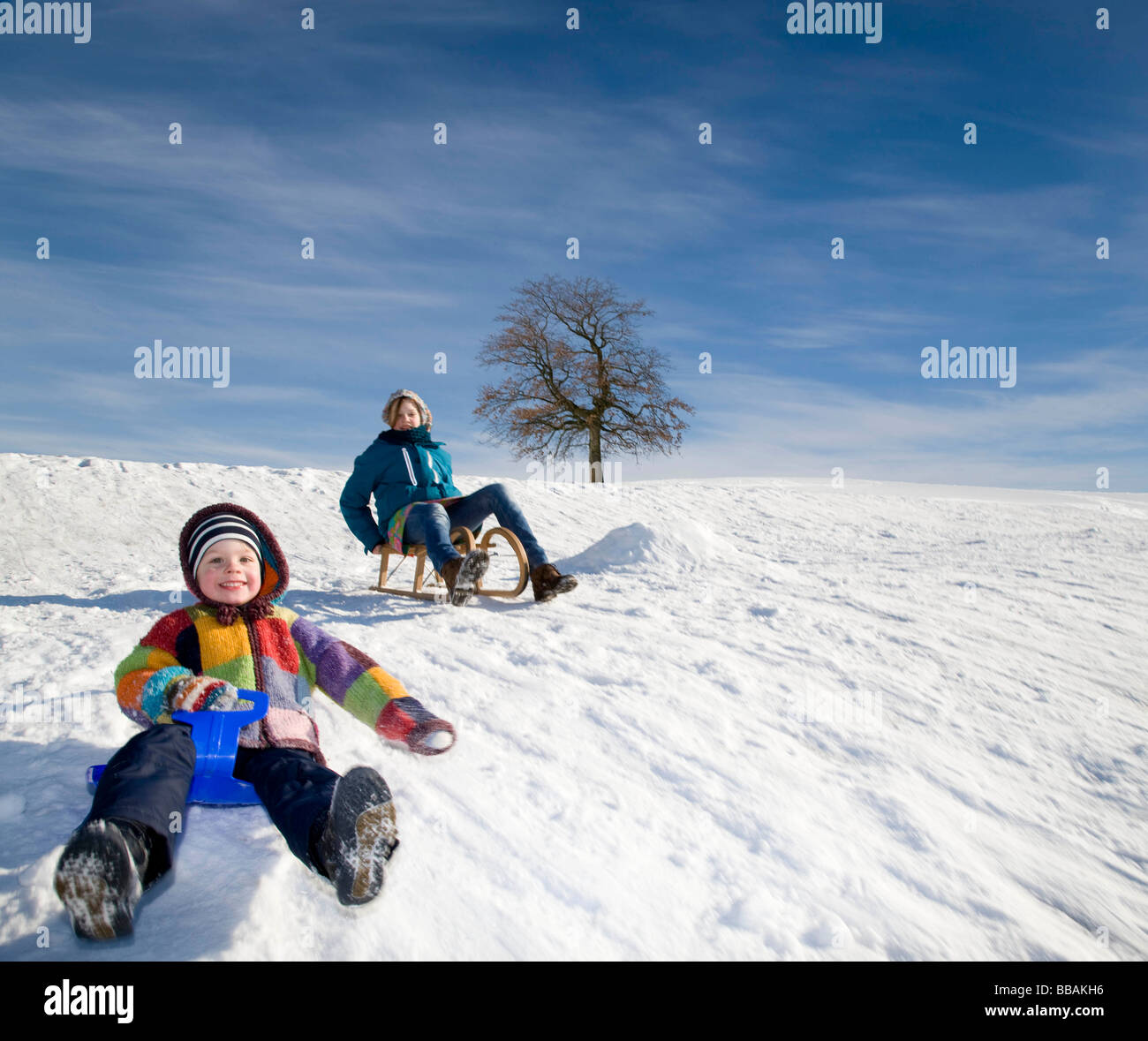 Boy and Girl riding a sledge in snow Stock Photo - Alamy