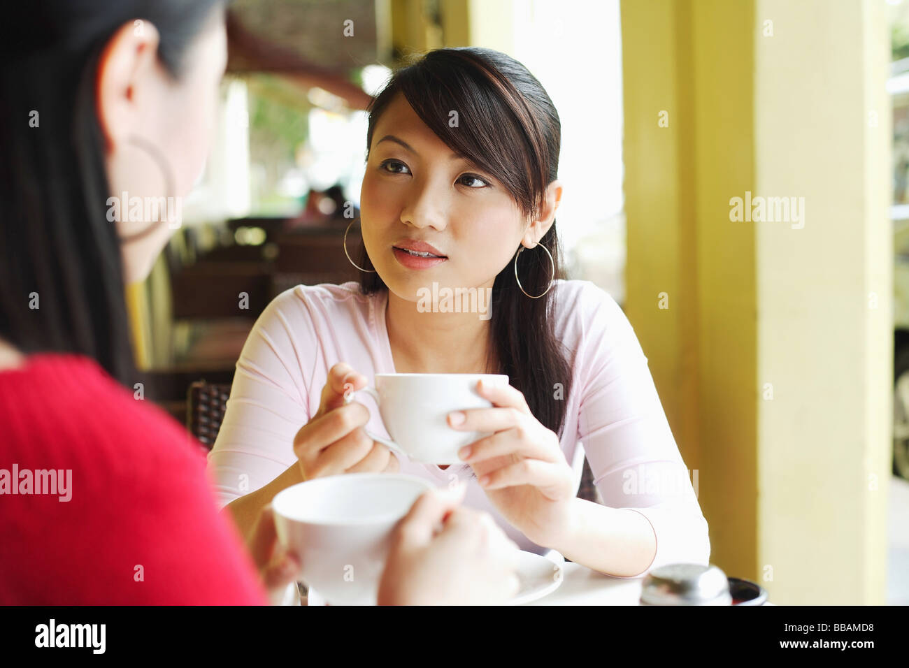 Young women at cafe, having coffee Stock Photo - Alamy