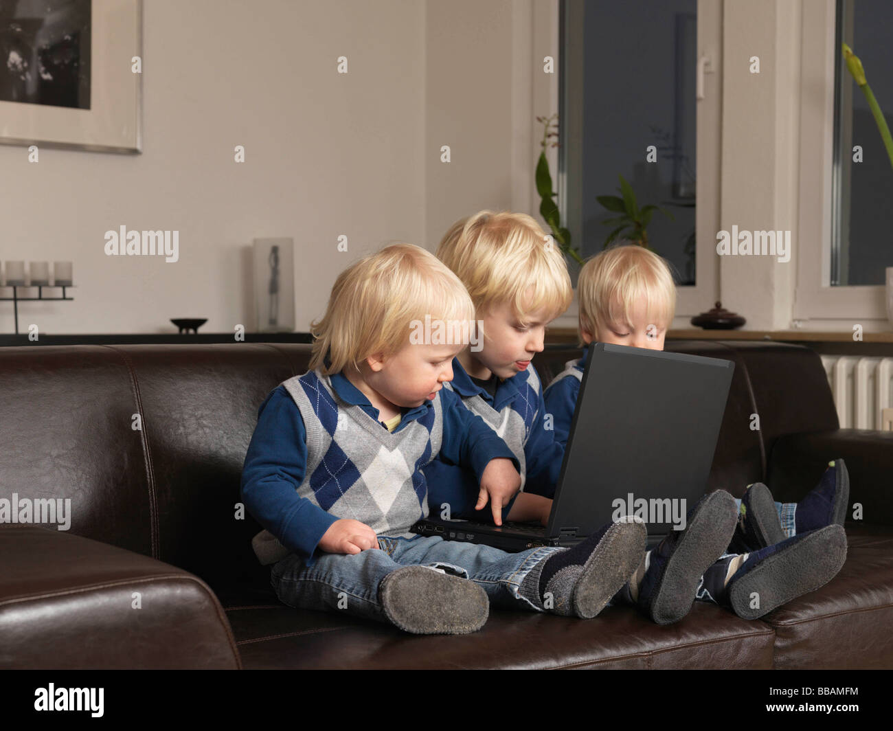 Three toddlers working on laptop Stock Photo - Alamy