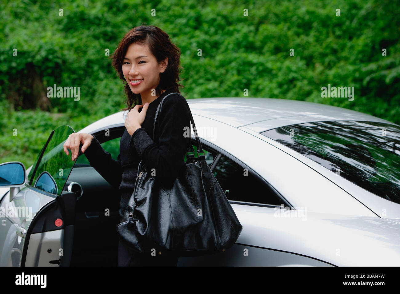 Woman getting into car, smiling at camera Stock Photo - Alamy