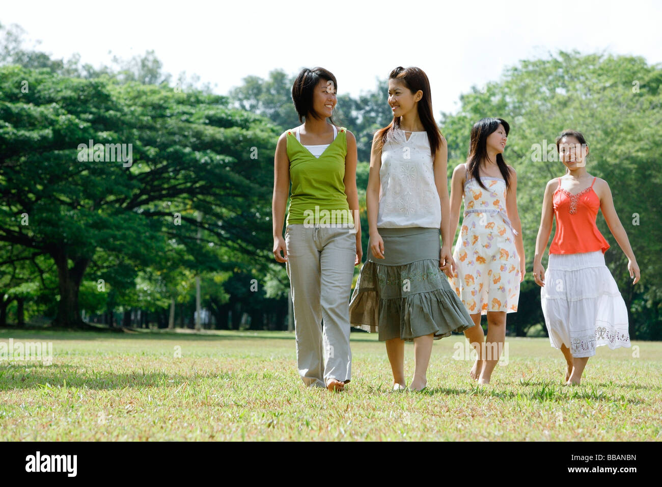 Four young women walking across field Stock Photo - Alamy