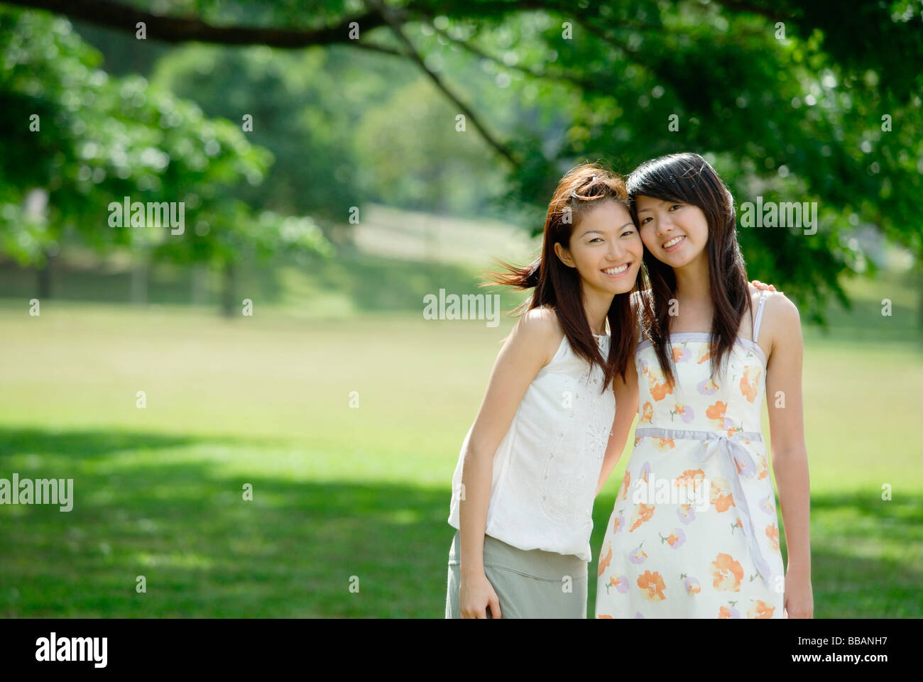 Two young women standing side by side, cheek to cheek Stock Photo - Alamy