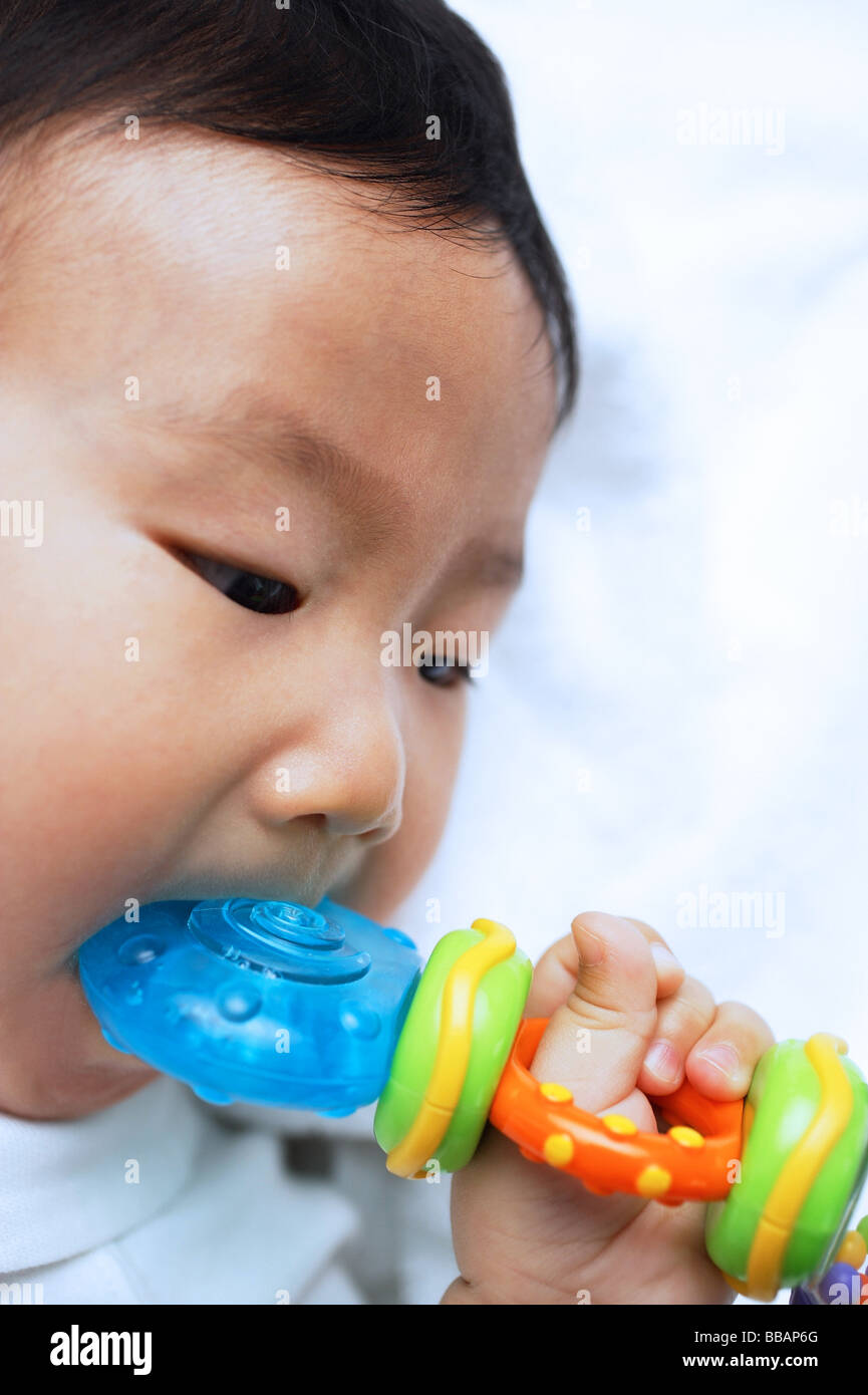 Infant boy biting toy, close-up Stock Photo - Alamy