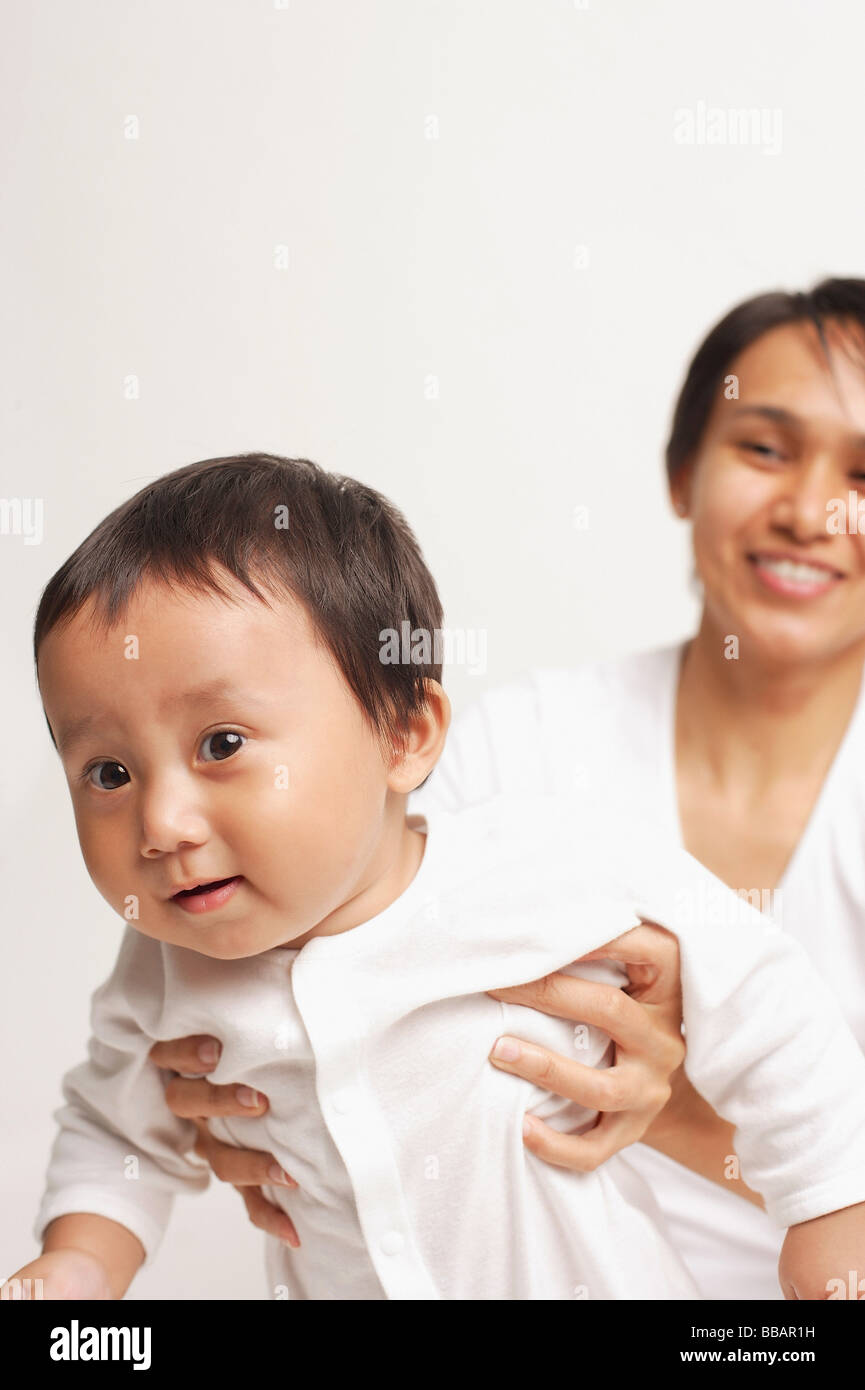 Mother carrying baby boy Stock Photo - Alamy