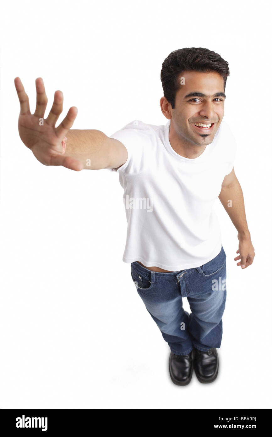 Man smiling at camera, arm outstretched, showing palm Stock Photo - Alamy