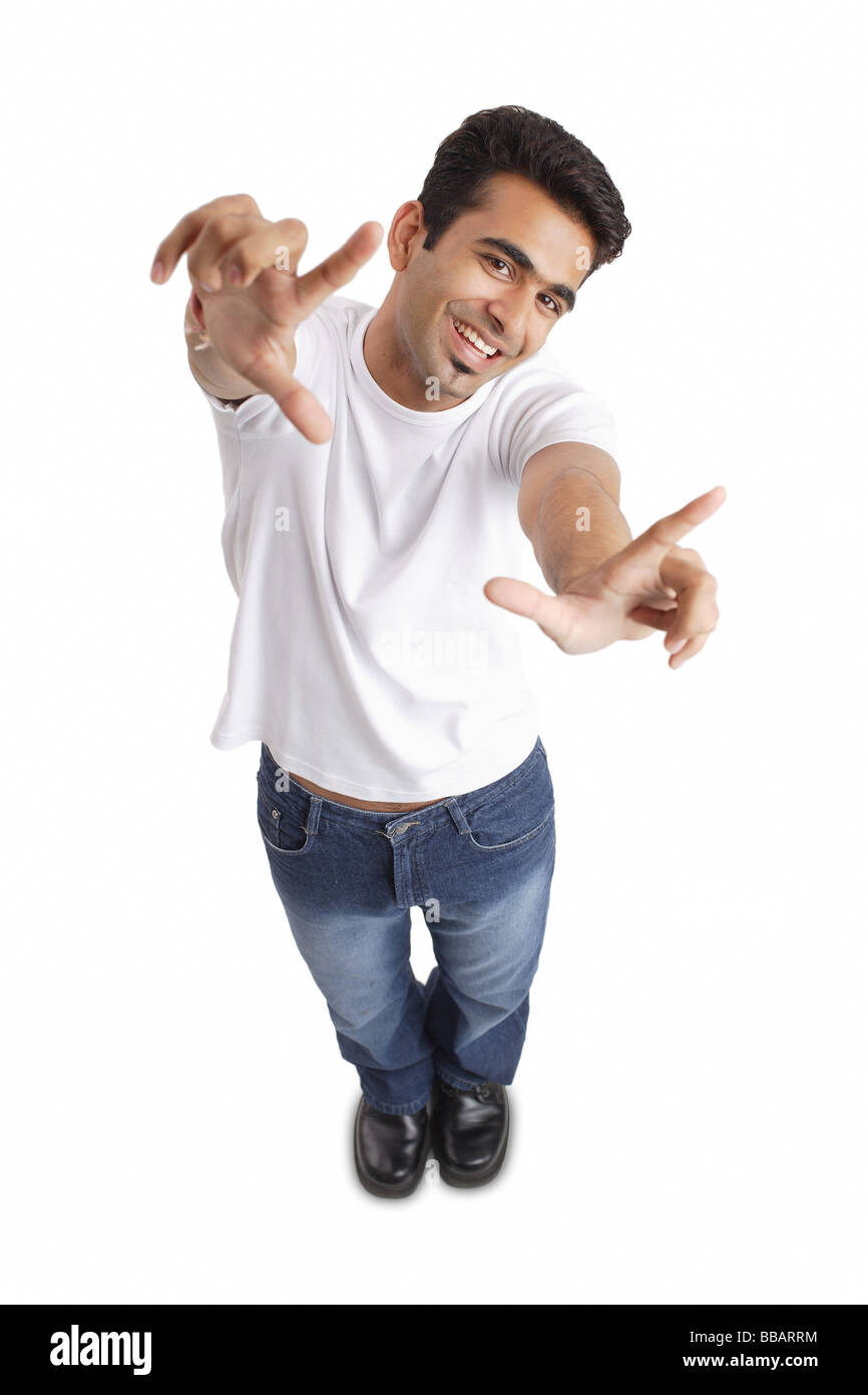 Man smiling at camera, arm outstretched, making hand sign Stock Photo ...