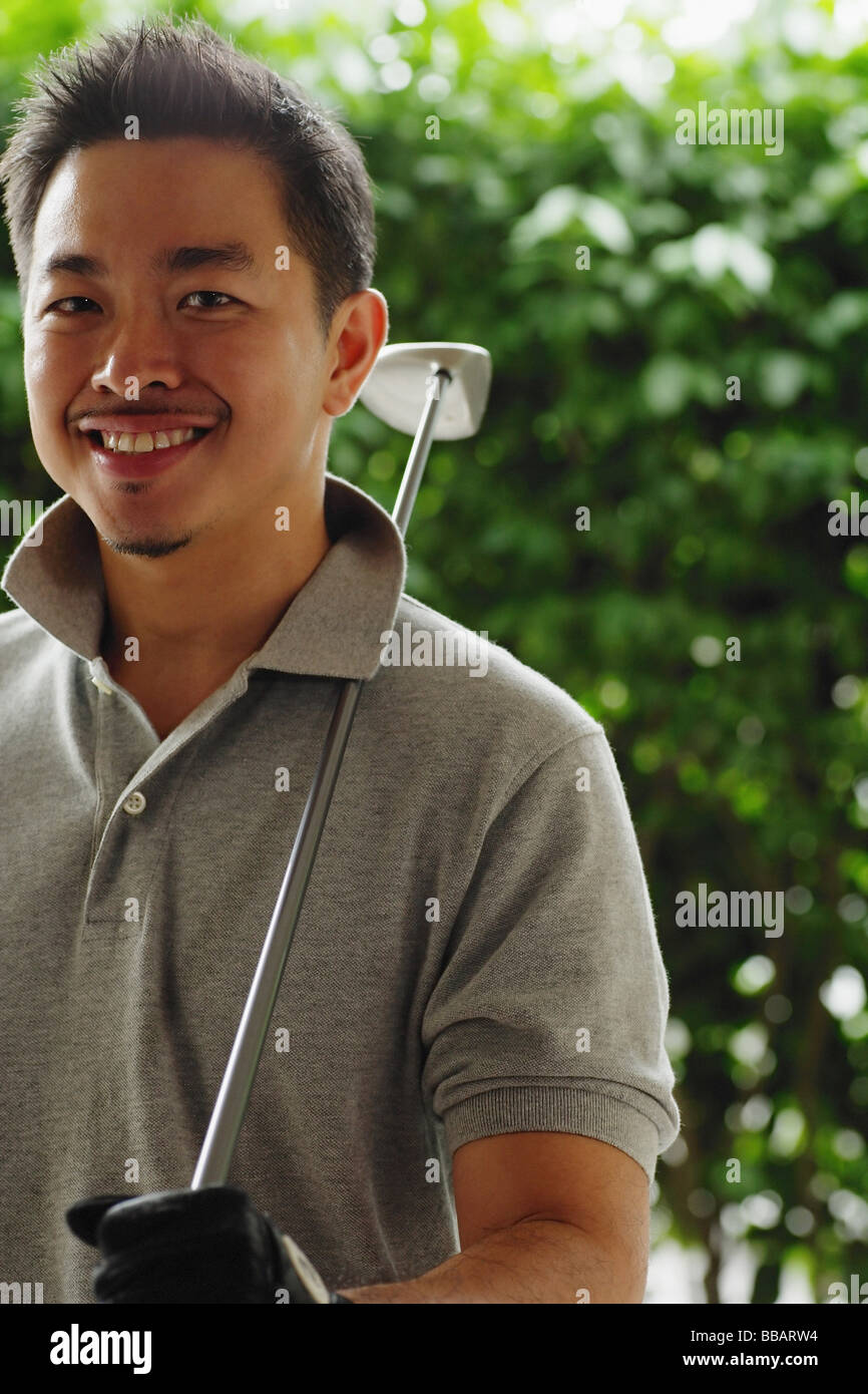 Man holding golf club, smiling at camera Stock Photo - Alamy