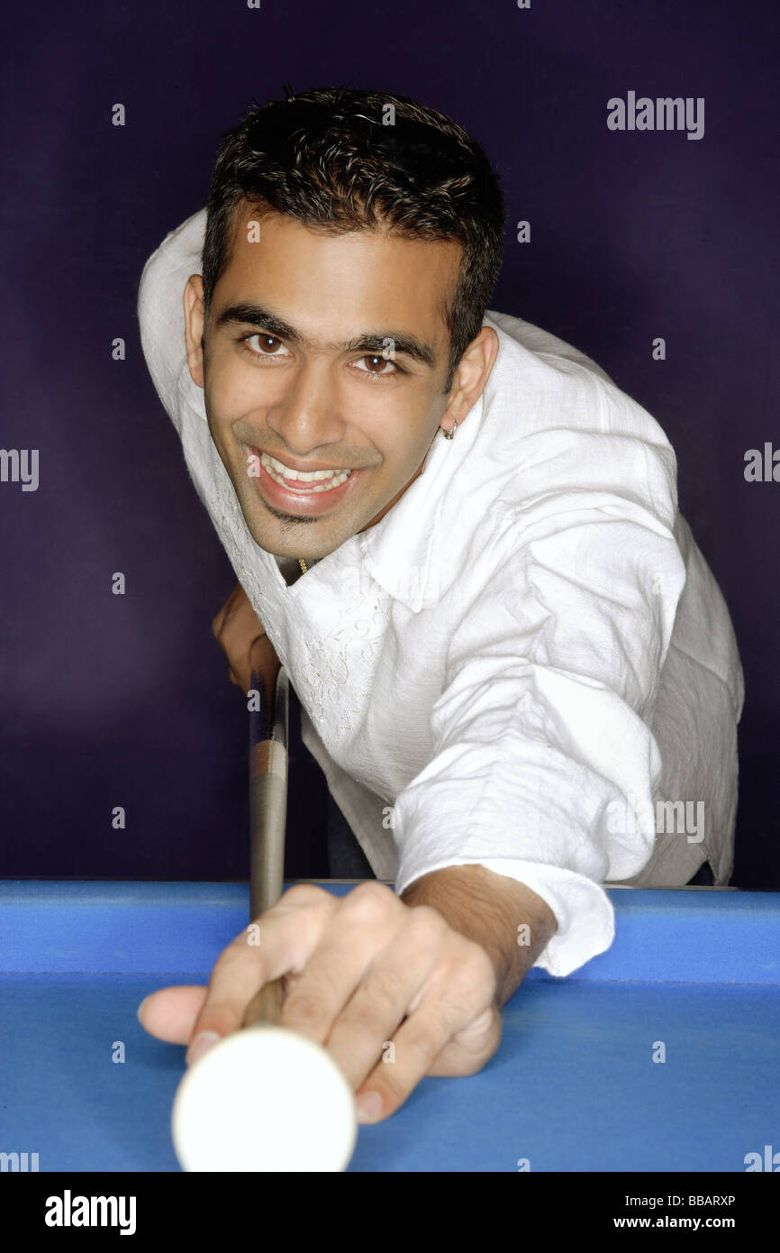 Young man playing pool, smiling at camera Stock Photo - Alamy