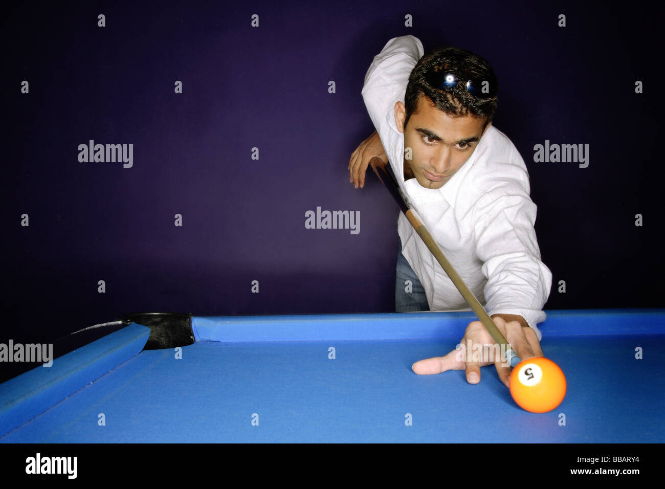 Young man preparing to hit pool ball Stock Photo - Alamy