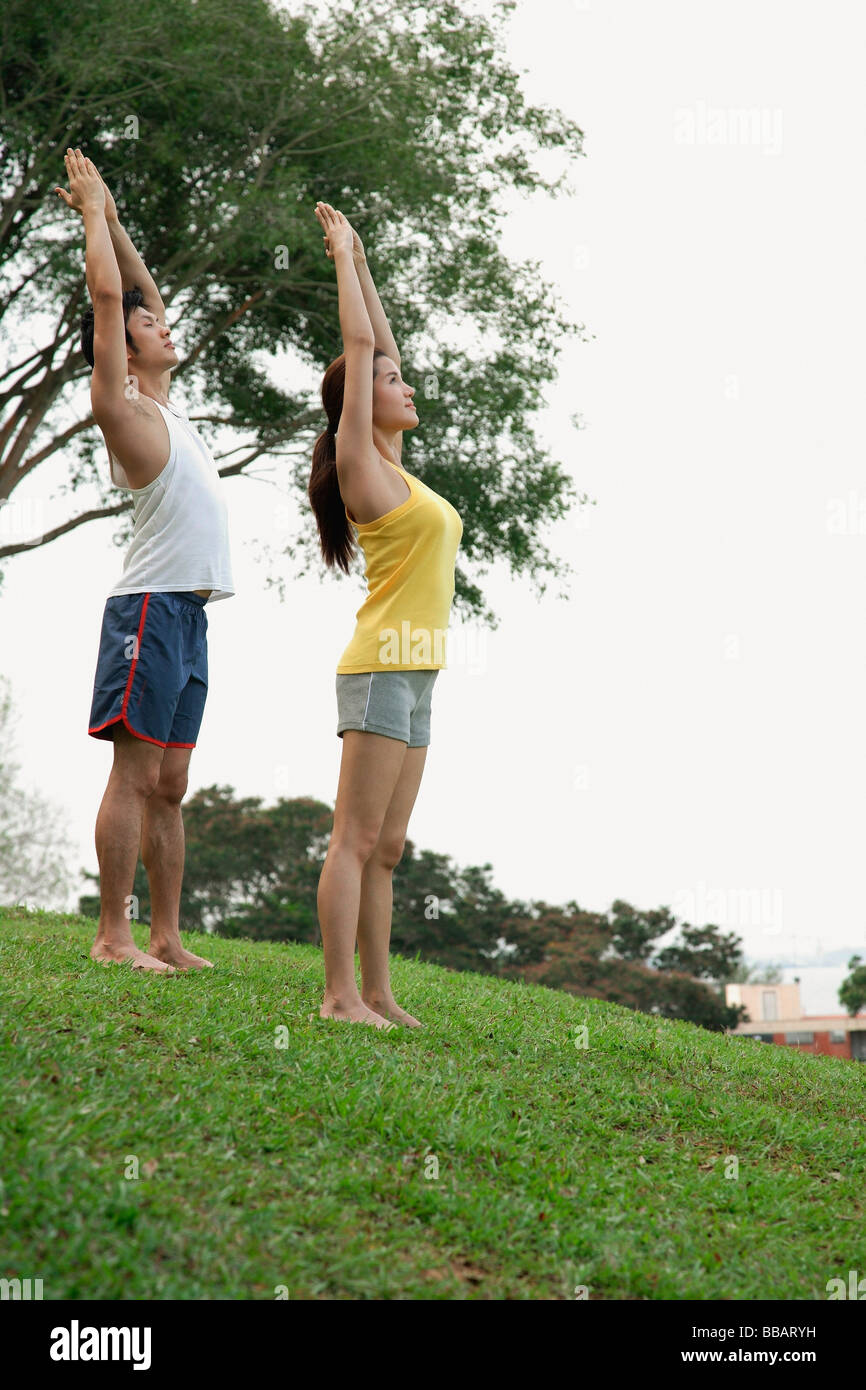Man and woman stretching, arms raised over head Stock Photo - Alamy